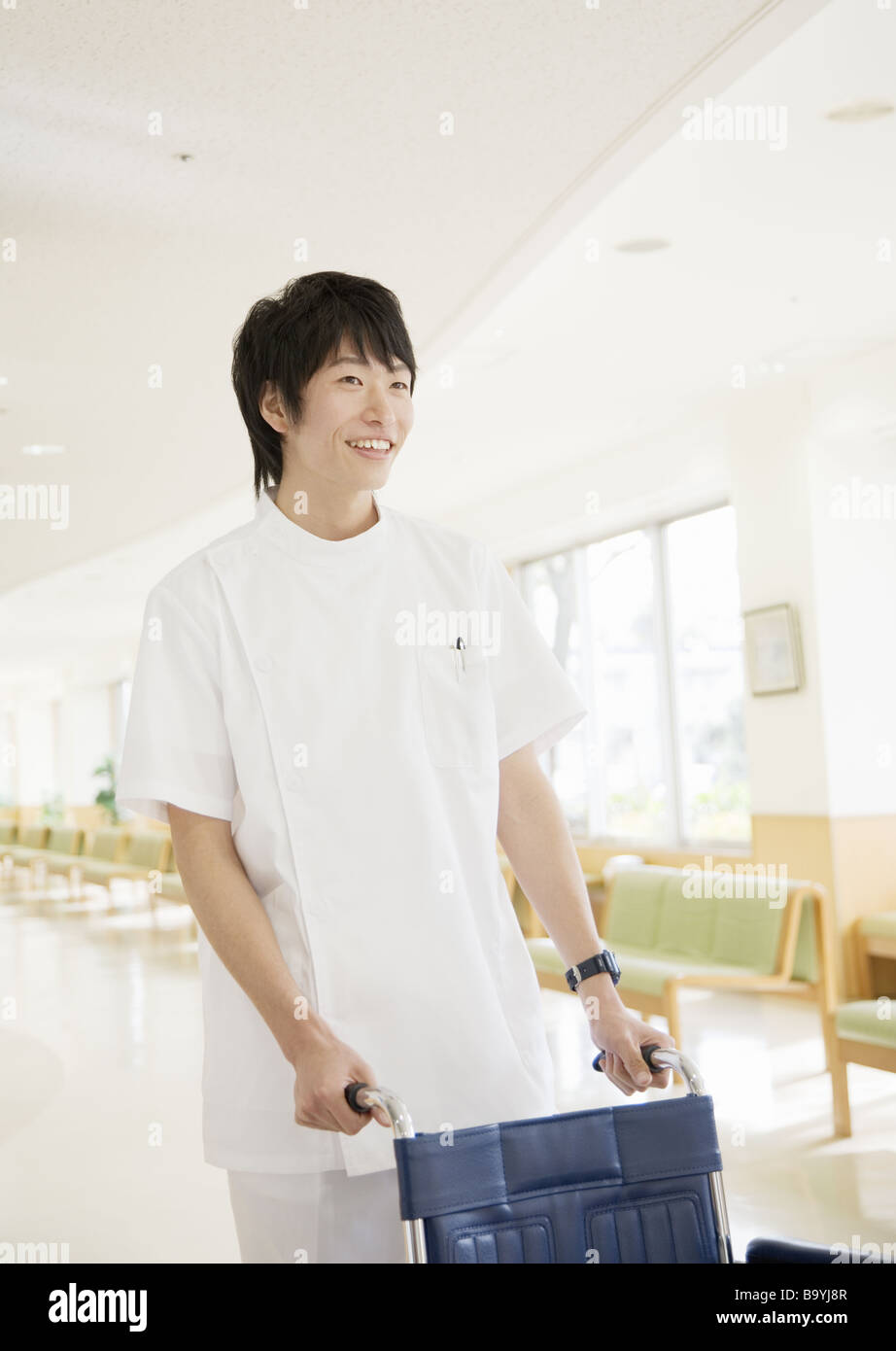A nurse pushing a wheelchair Stock Photo - Alamy