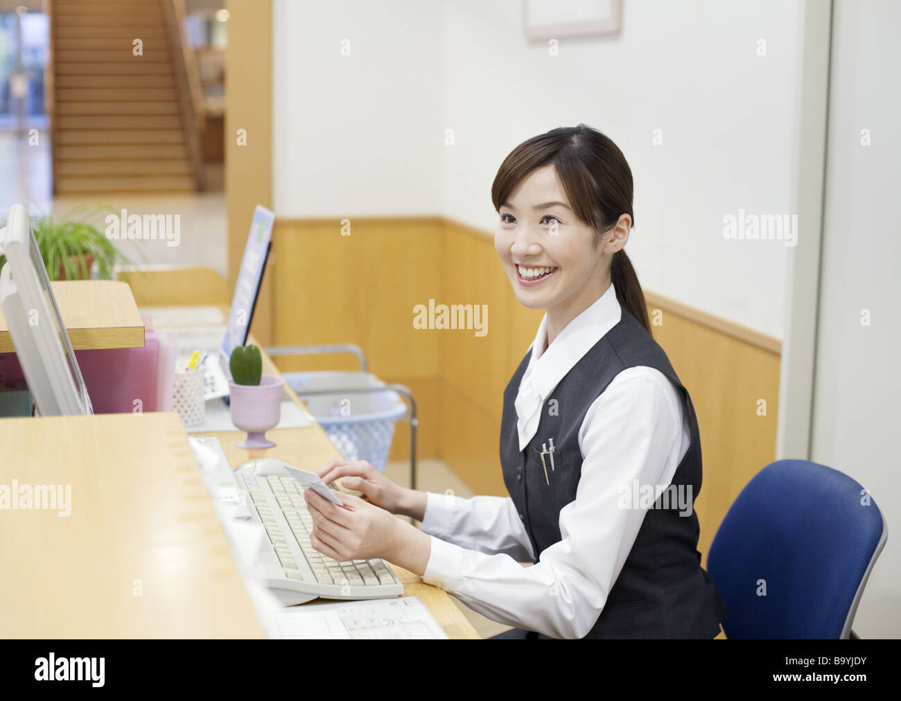 A smiling receptionist Stock Photo - Alamy