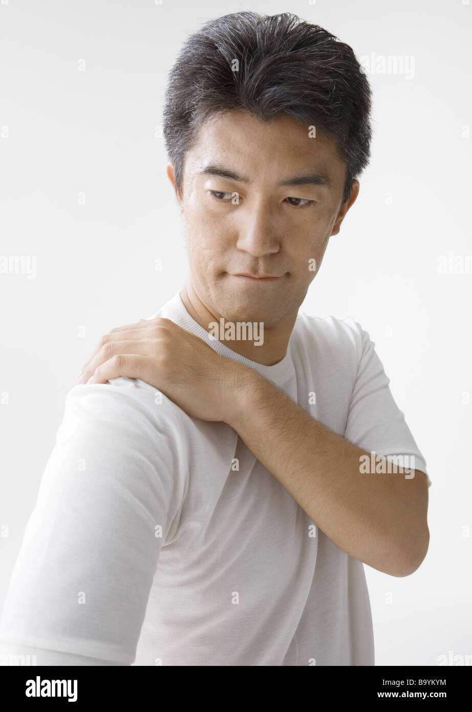 A man touching his shoulder Stock Photo - Alamy