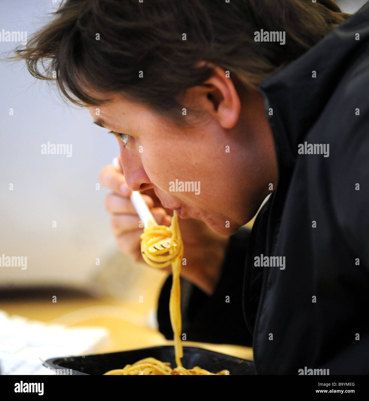 Woman eating spaghetti with fork Stock Photo - Alamy
