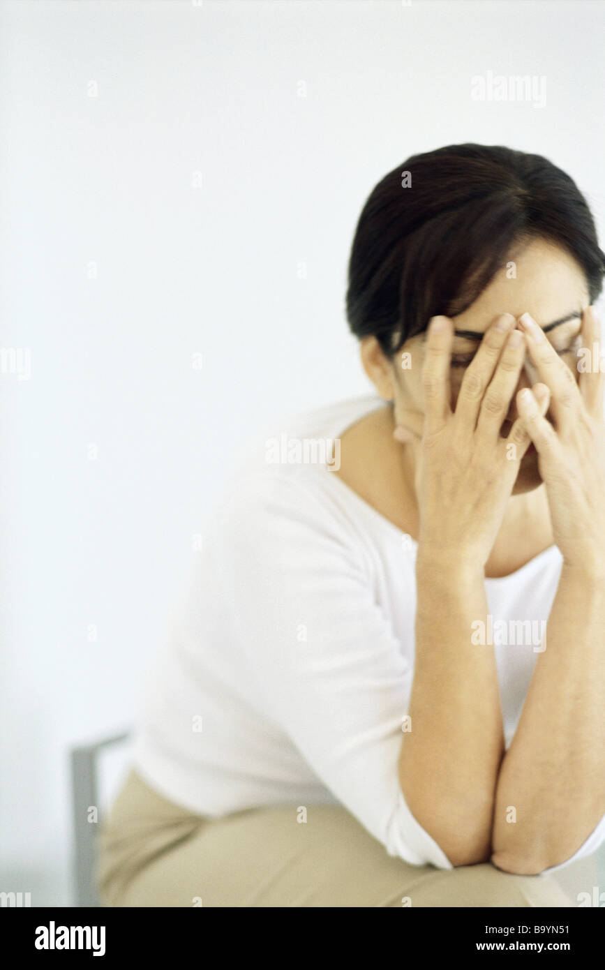 Woman covering face with hands Stock Photo - Alamy