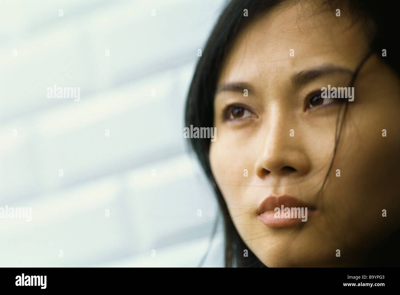 Woman with hair blowing across face, portrait Stock Photo - Alamy