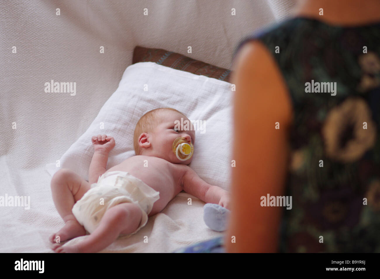 baby with onlooking mother Stock Photo - Alamy