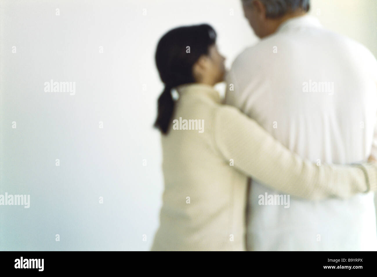 Woman embracing husband, displaying concern, rear view Stock Photo - Alamy