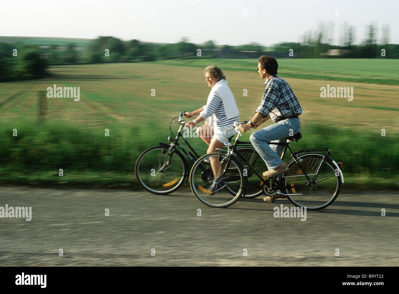 Couple riding bicycles through countryside Stock Photo - Alamy