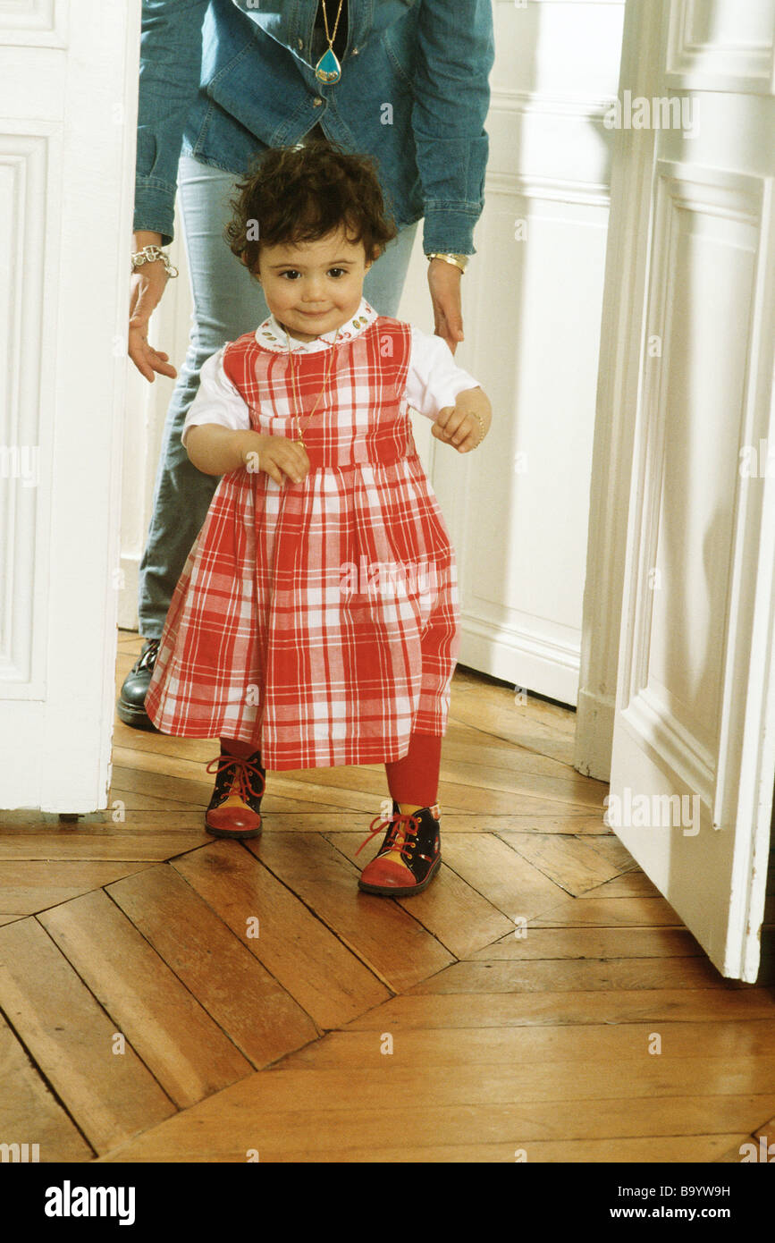 Little girl walking, mother following behind Stock Photo - Alamy