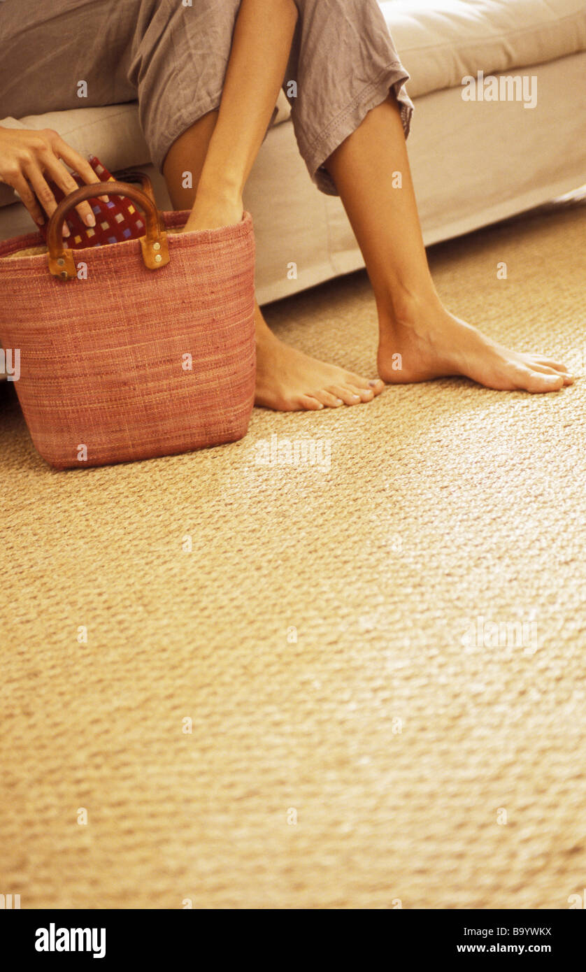 Woman reaching into bag on floor, low section Stock Photo - Alamy