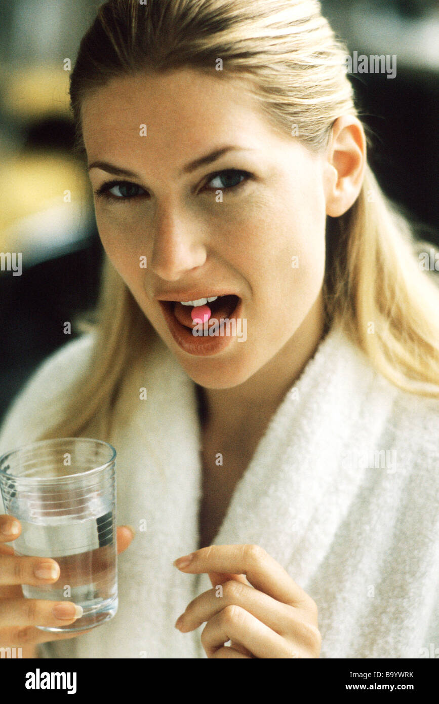 Woman opening mouth to show tablet on tongue Stock Photo - Alamy