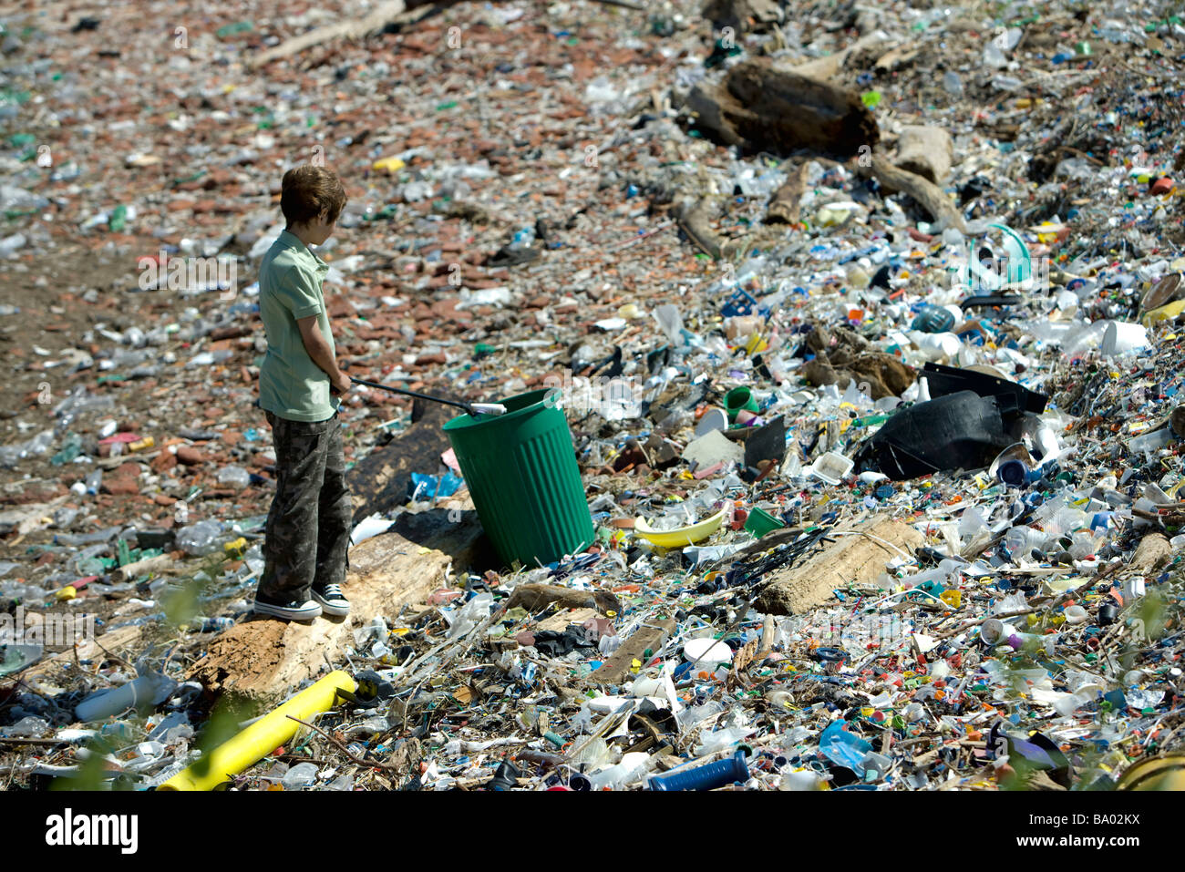 Boy picking up garbage in dump, high angle view Stock Photo - Alamy