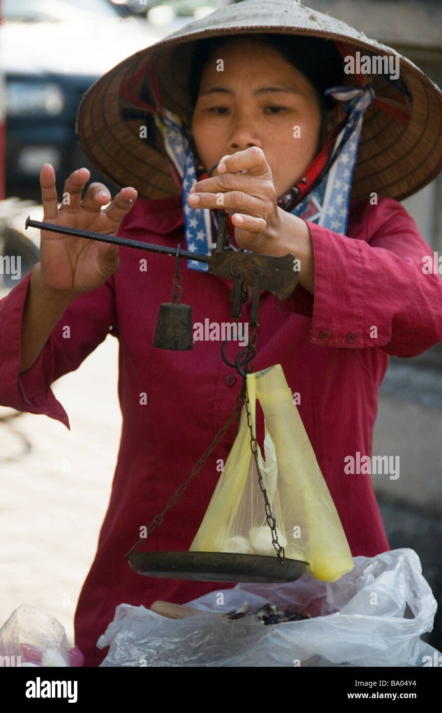 vendor weighing her wares in Hanoi Vietnam Stock Photo - Alamy
