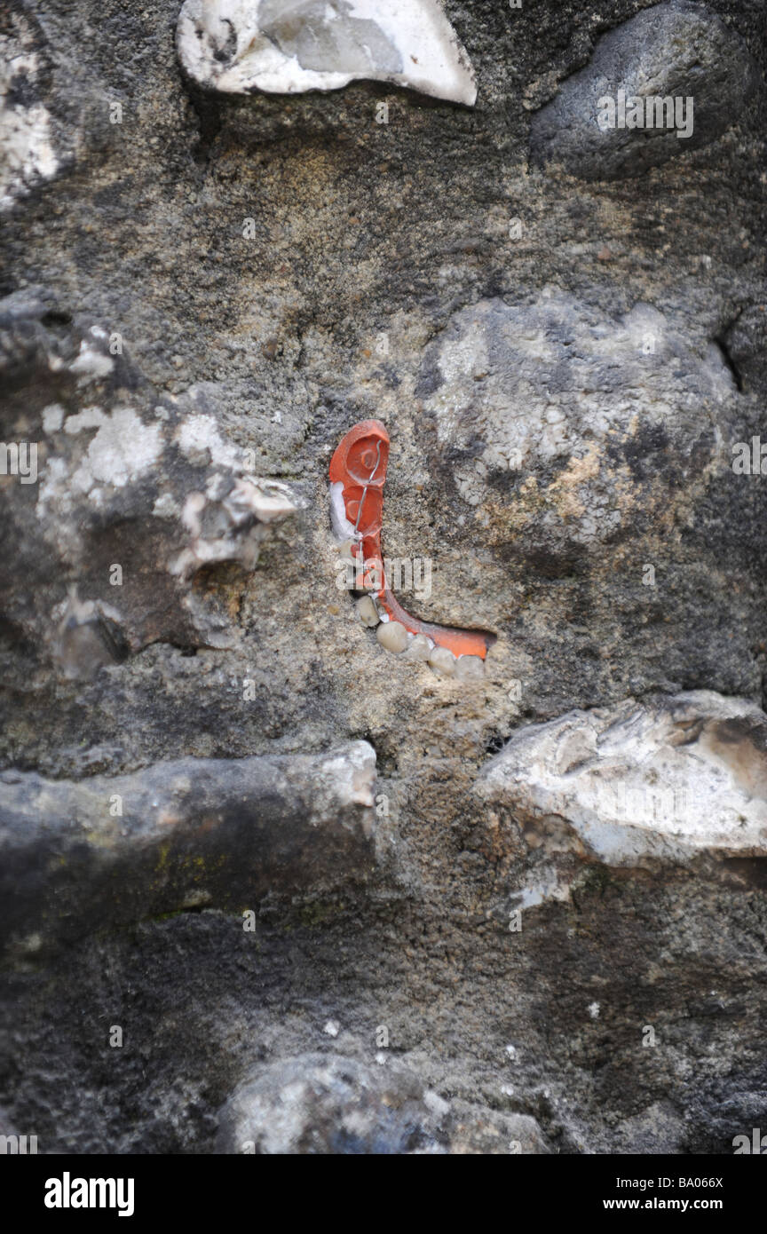 A set of false teeth which have been part of this historic flint wall ...