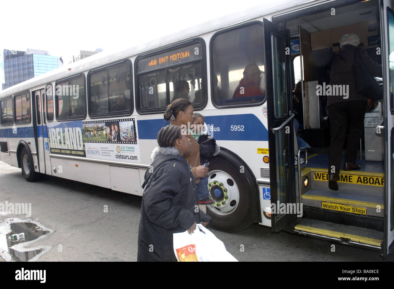 A family boards the B60 bus on Queens Boulevard in the New York borough ...