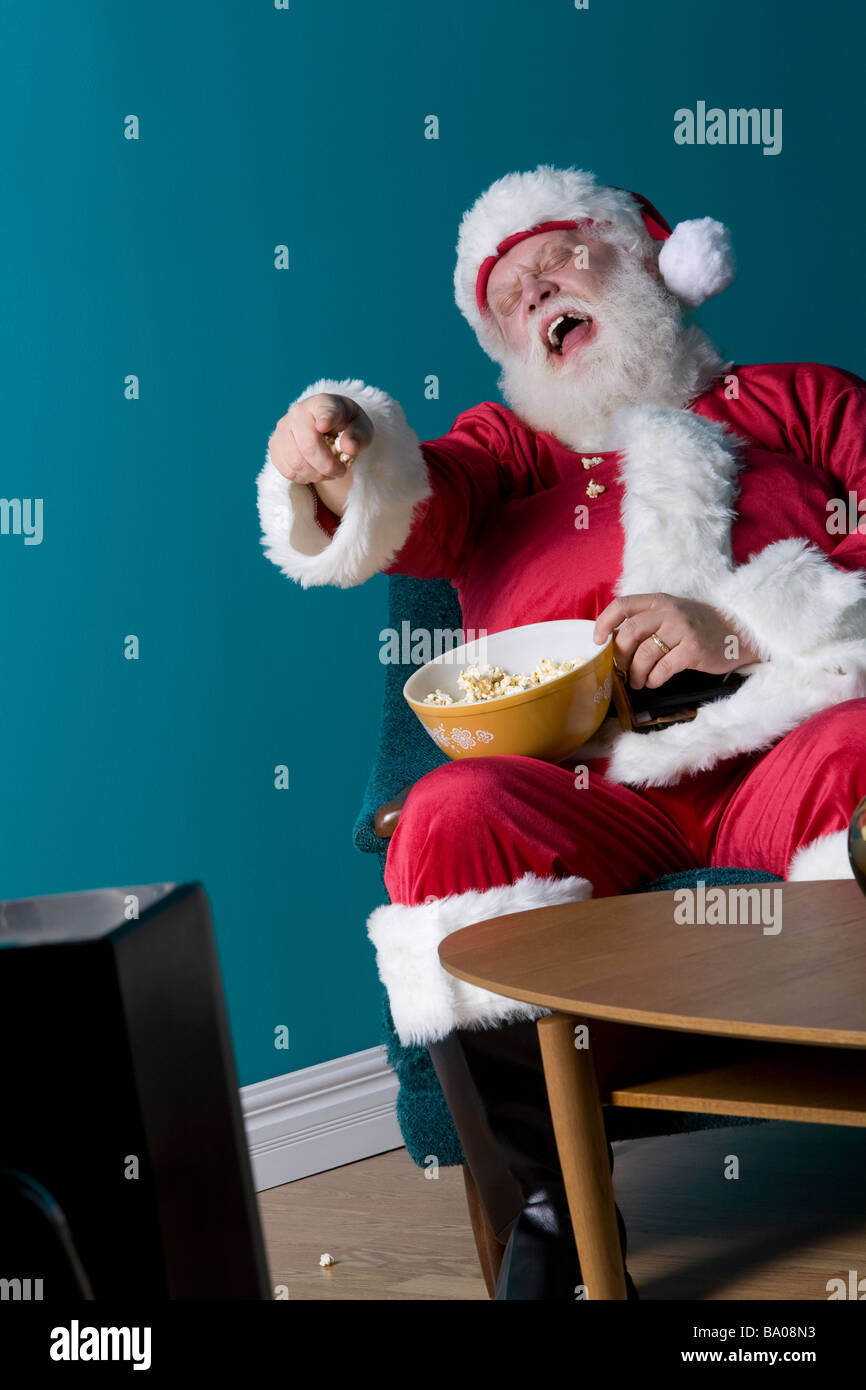 Santa sitting and eating popcorn Stock Photo - Alamy