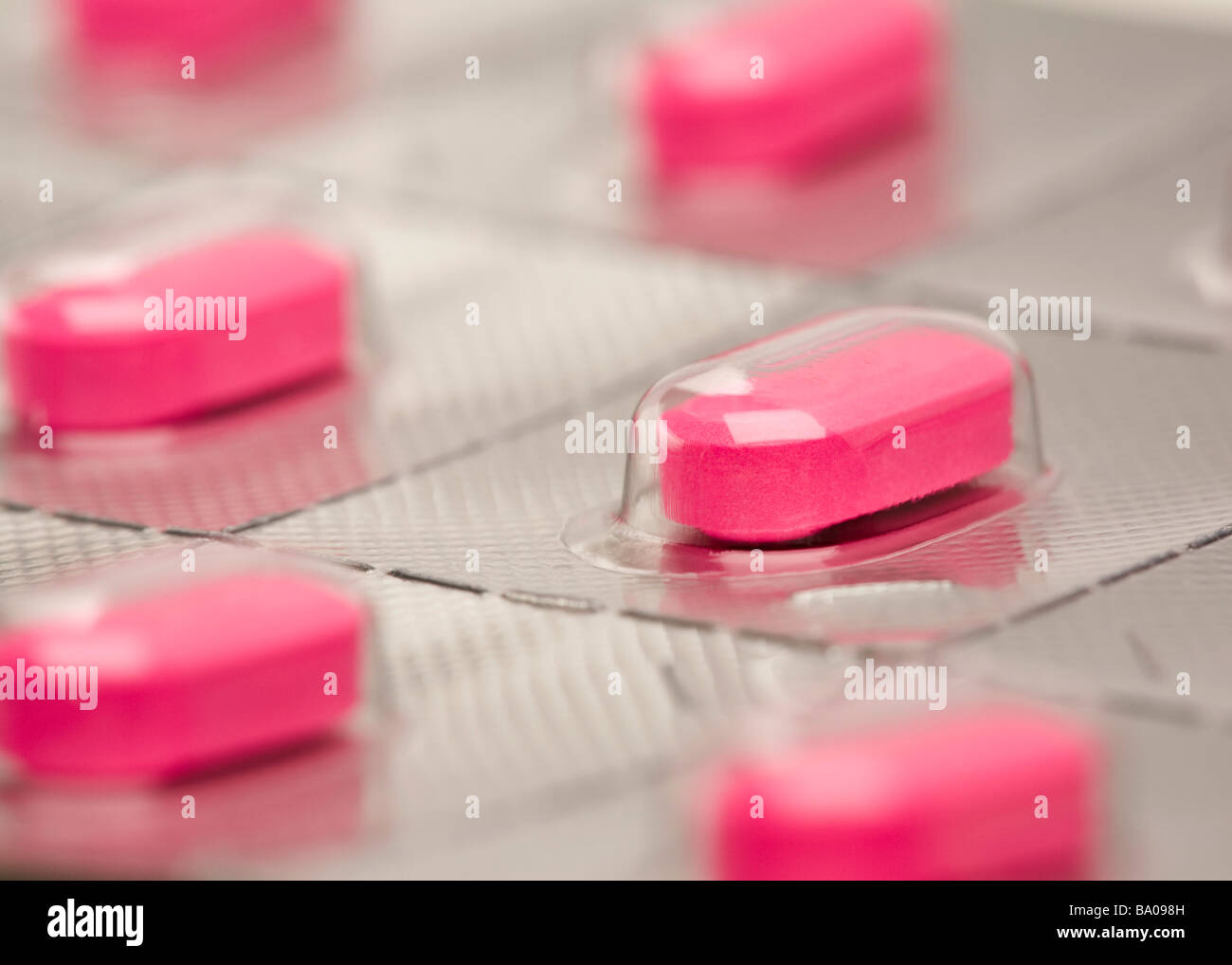 Individually wrapped pink medicine caplets Stock Photo - Alamy