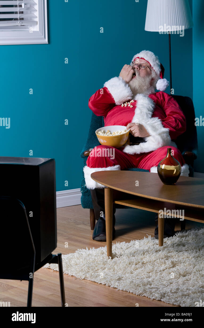 Santa sitting and eating popcorn Stock Photo - Alamy
