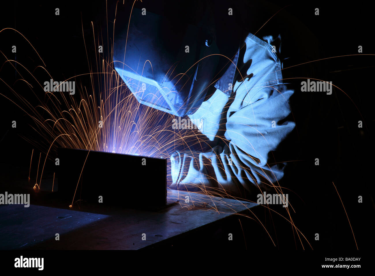 Welder working with sparks flying Stock Photo - Alamy