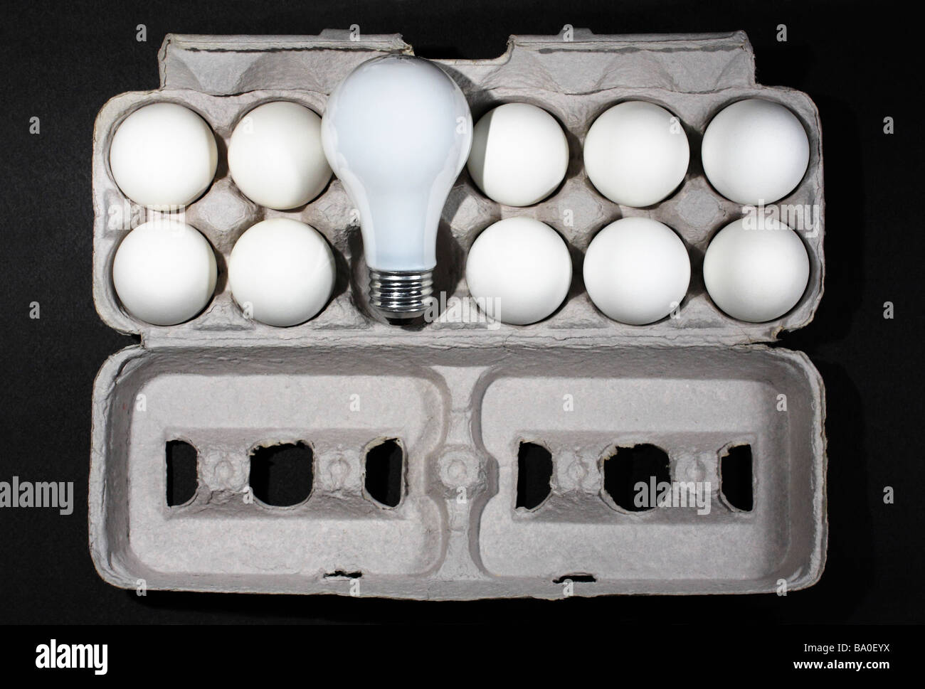 Egg carton with light bulb on a black background Stock Photo - Alamy