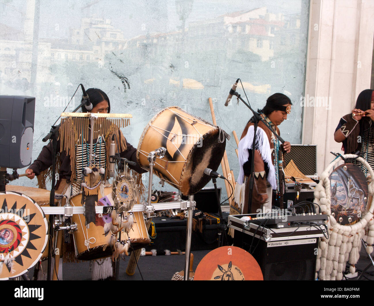 American Indians play musical instruments in a square in the heart of ...