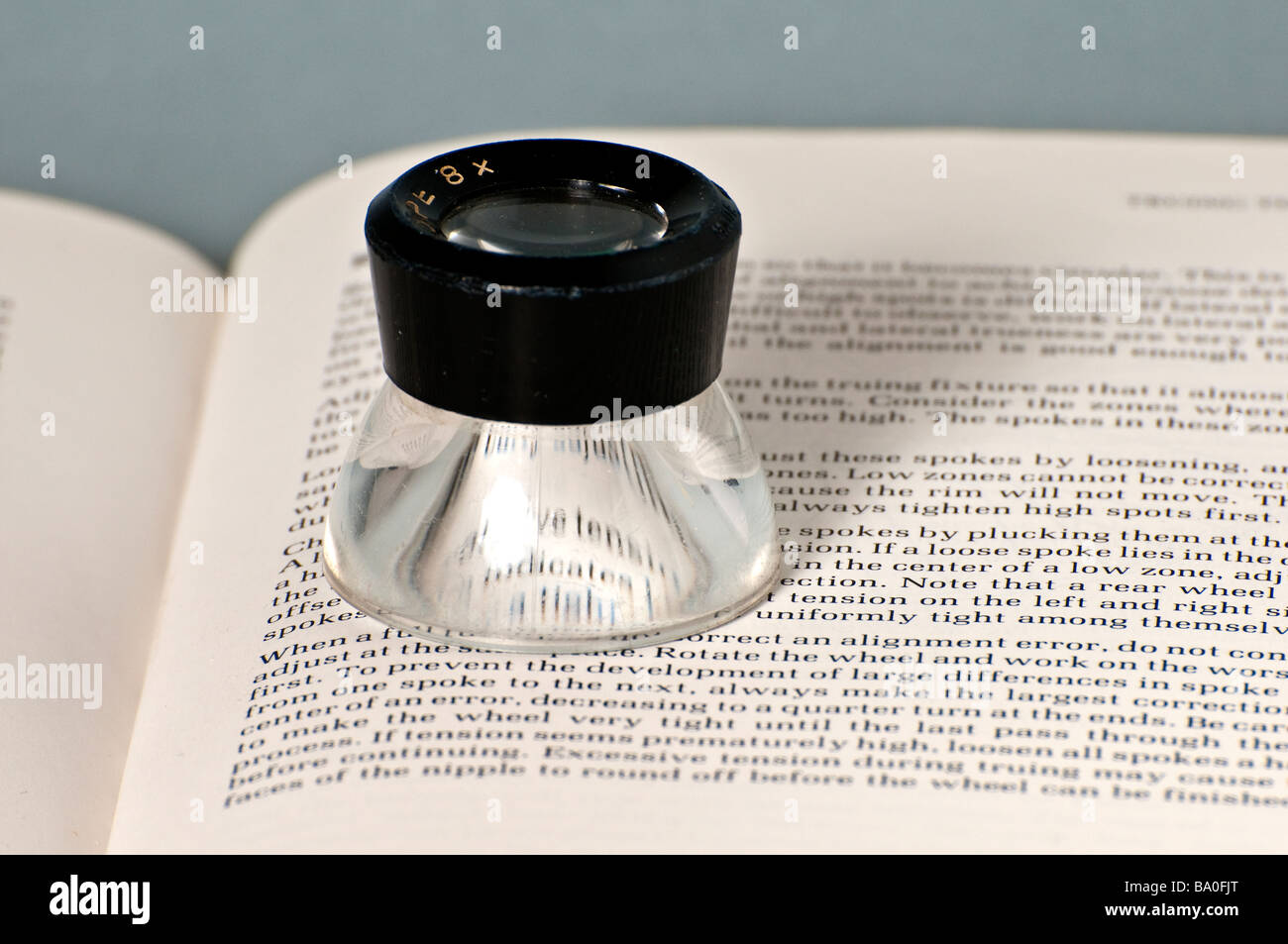 Open book with a magnifying lupe Stock Photo - Alamy