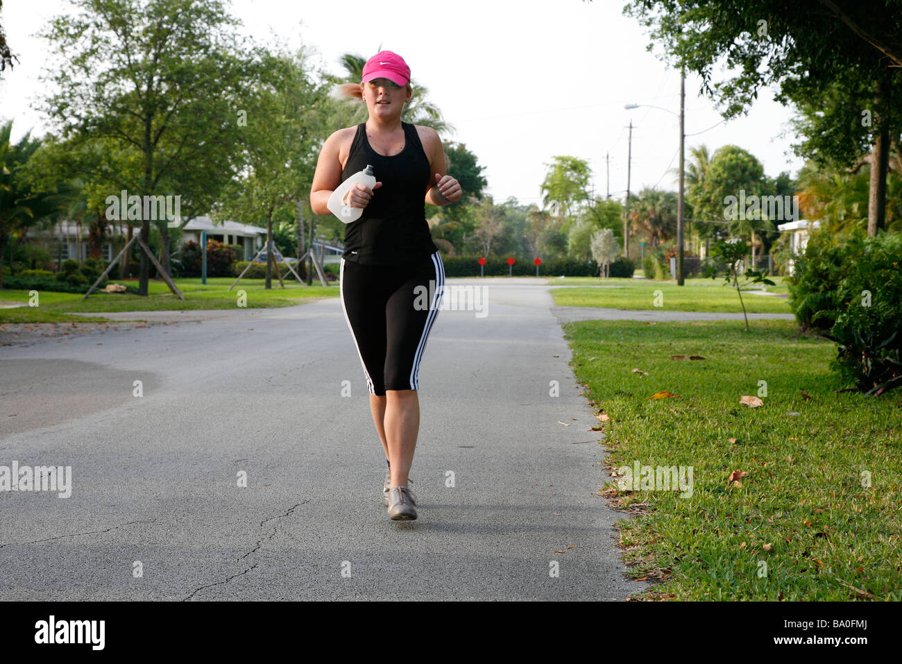 female running along a road Stock Photo - Alamy