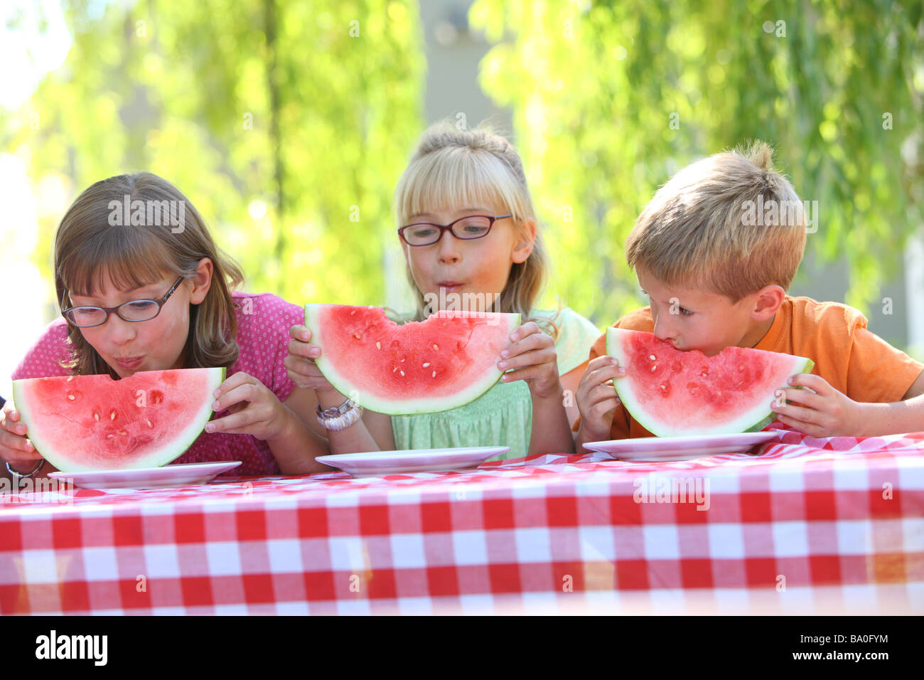 Three children eating watermelon Stock Photo - Alamy