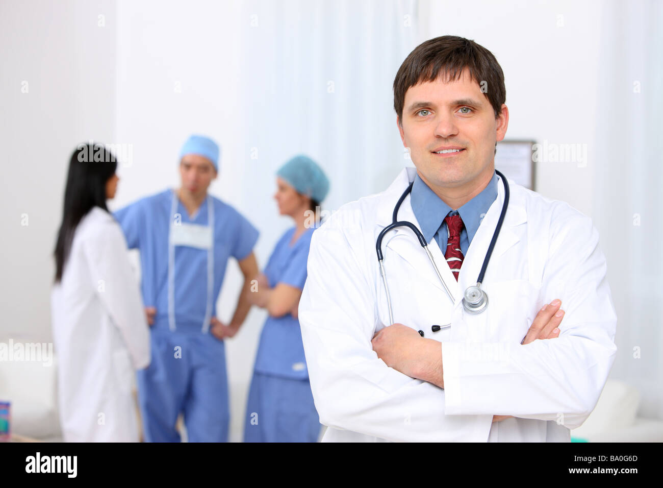 Doctor portrait with medical personnel in background Stock Photo - Alamy