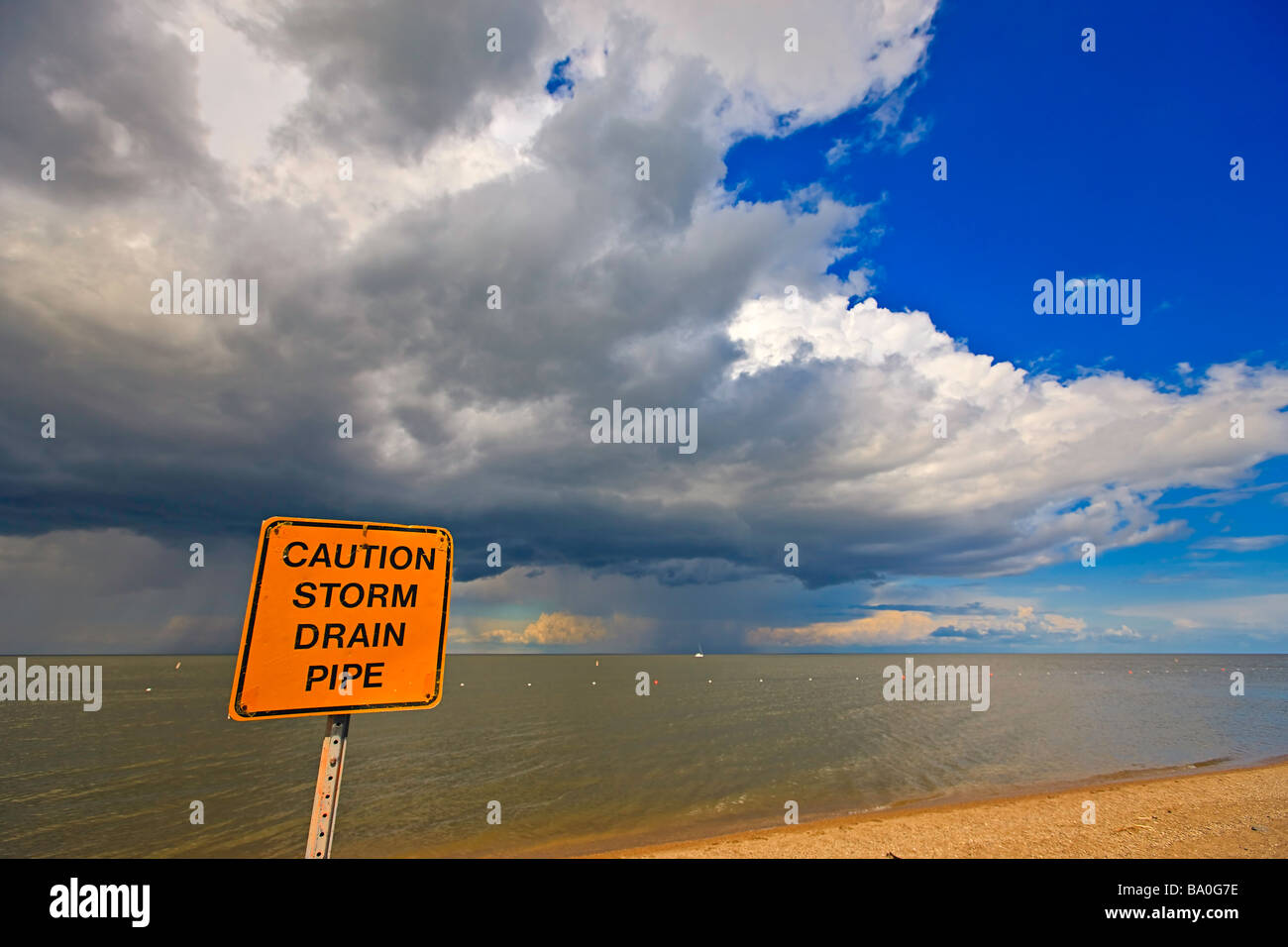 Caution sign on the sandy shores of Lake Winnipeg with threatening ...