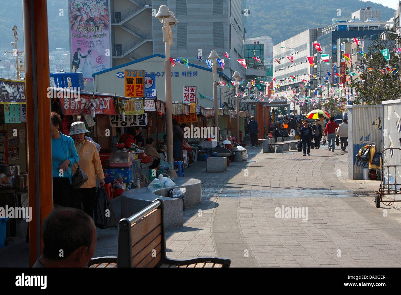 A fish market street in the city of Busan decorated with coloful flags ...