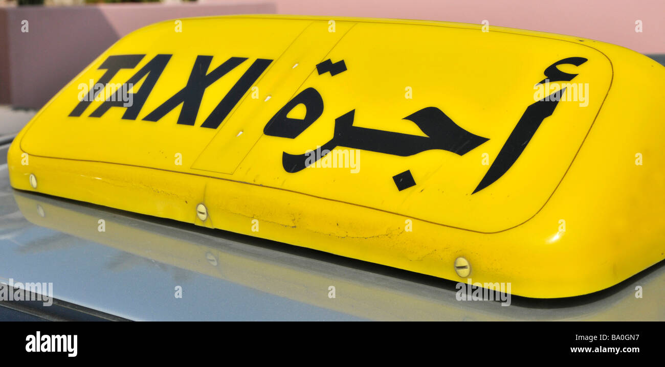 Abu Dhabi close up of roof mounted yellow bilingual taxi cab sign ...
