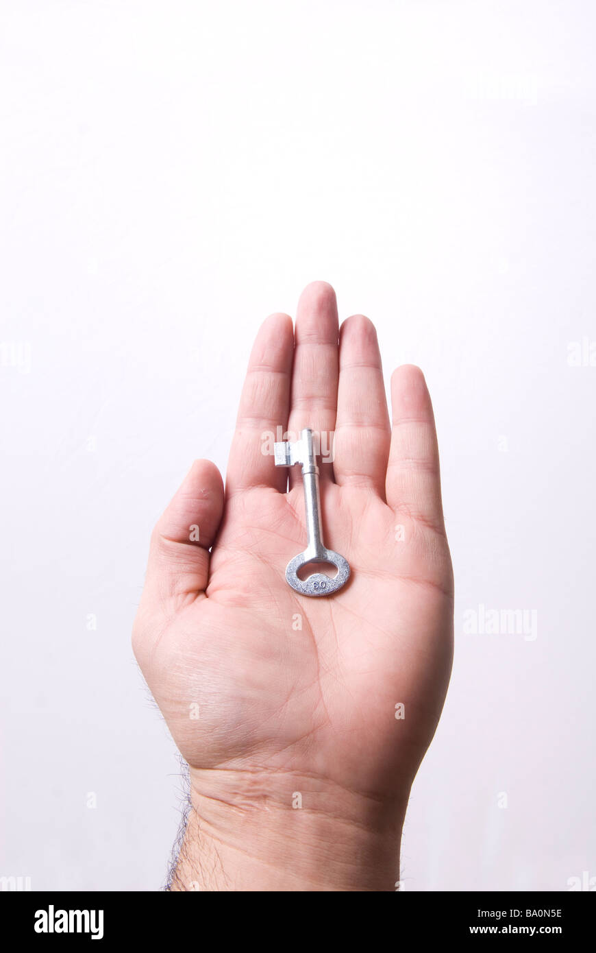 Hand holding a house key against a white background Stock Photo - Alamy