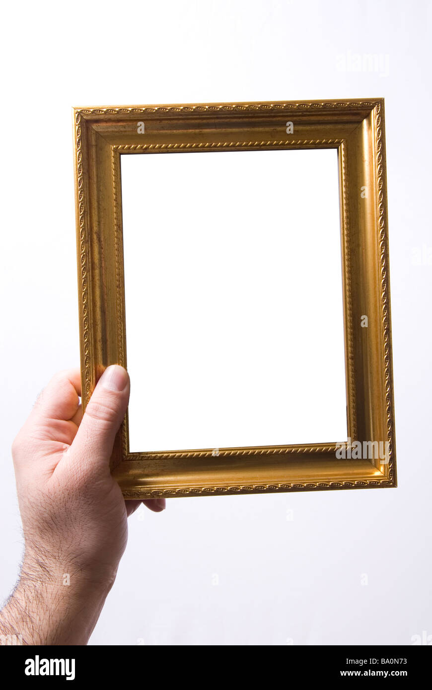 Hand holding a golden picture frame against a white background Stock ...