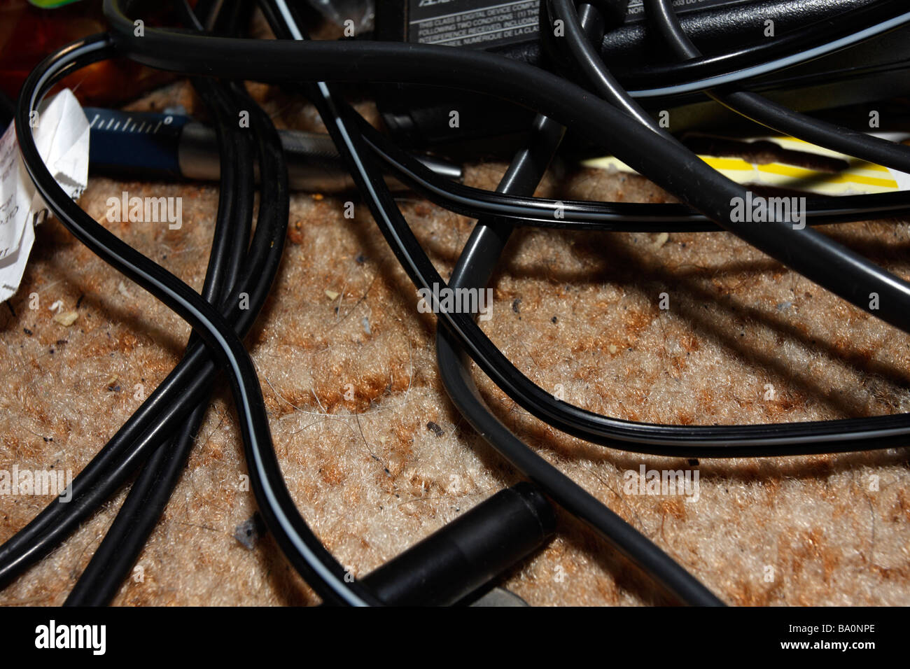 Black electronics and electric wires on brown carpeting Stock Photo - Alamy