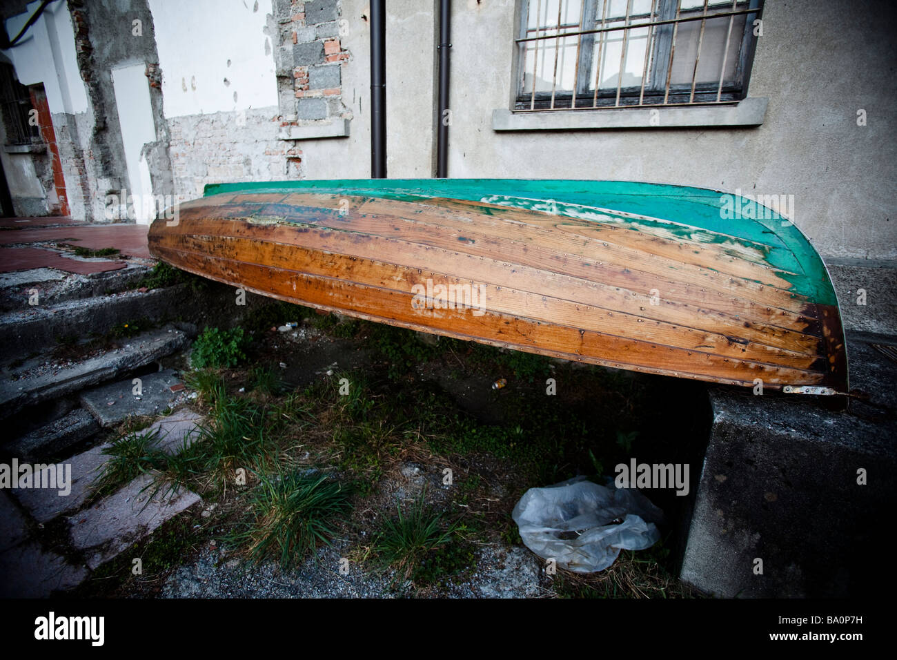 Wooden fishing boat drying on a street in front of house in San Pietro ...
