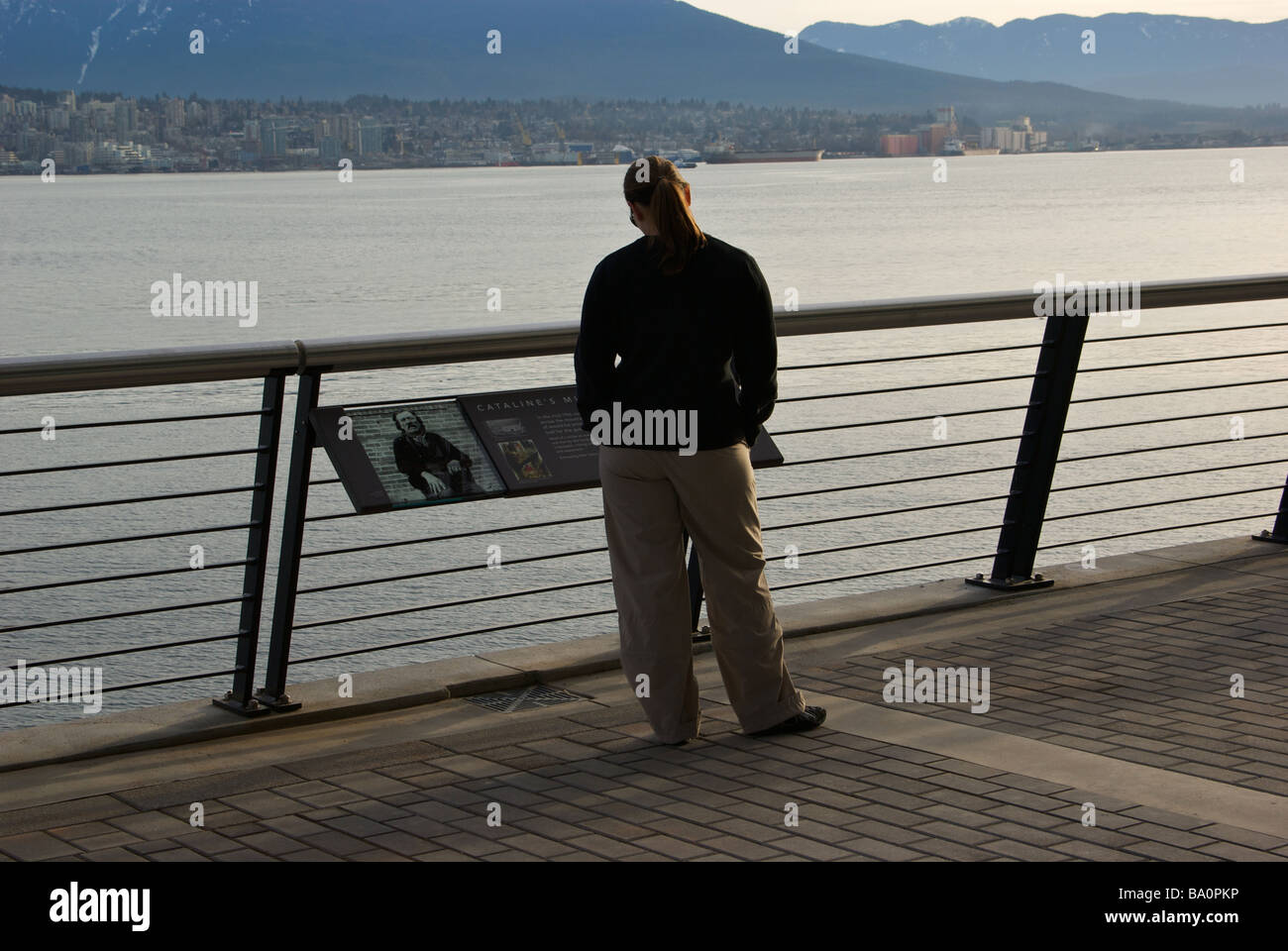 Woman reading historical information sign at Vancouver Trade Convention ...