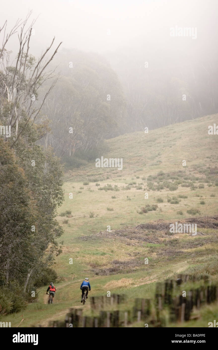 Two enduro riders push uphill during a race in the fog Stock Photo - Alamy