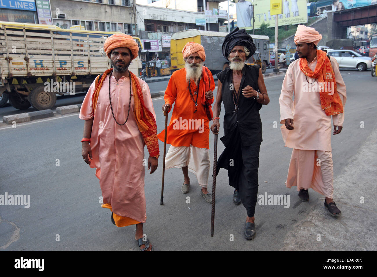Sadhus or Holy men walking the streets of Hyderabad India presenting a ...