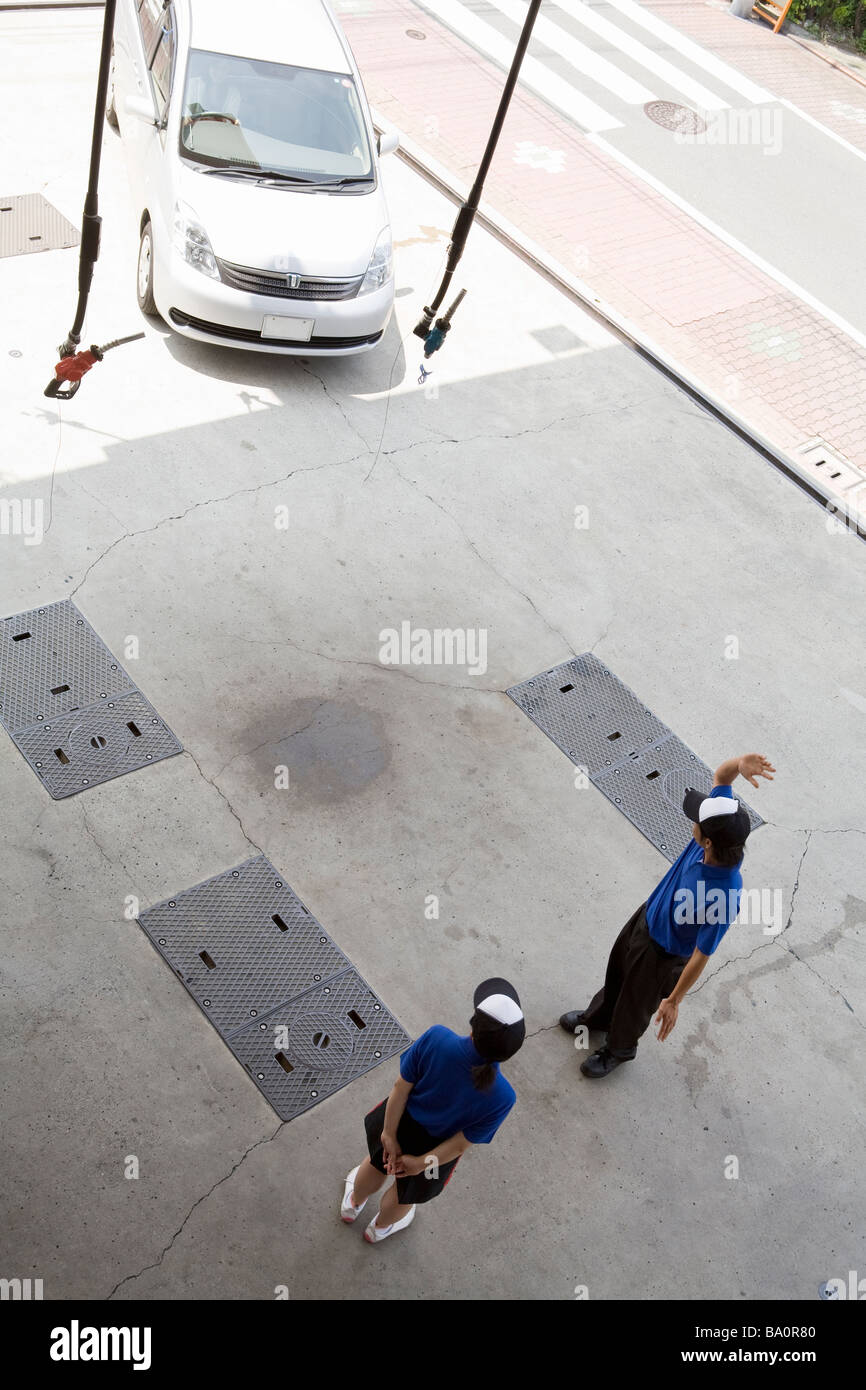 Gas station clerk guiding car Stock Photo - Alamy