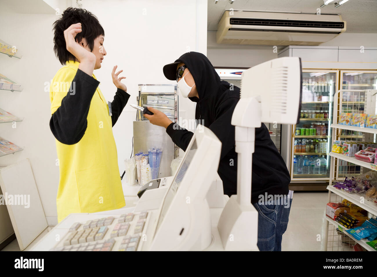 Robber threatening convenience store clerk Stock Photo - Alamy