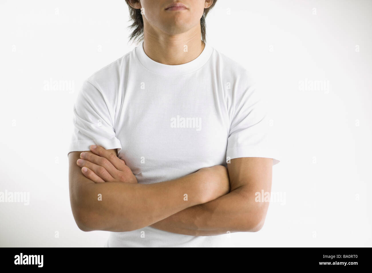 Young man arms crossed Stock Photo - Alamy