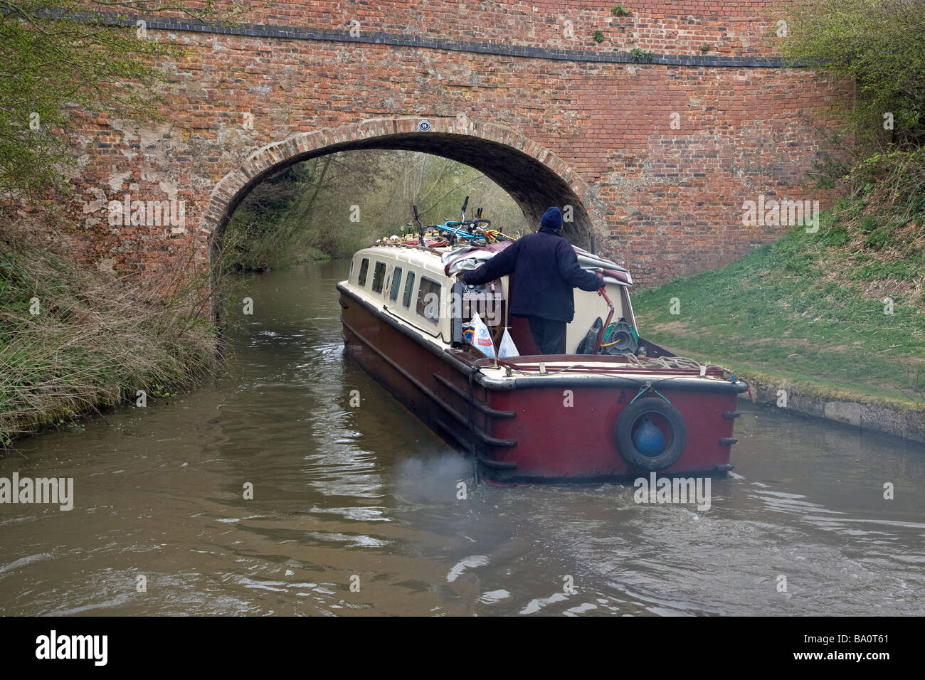 Longboat Going Under Bridge on Grand Union Canal Stock Photo - Alamy