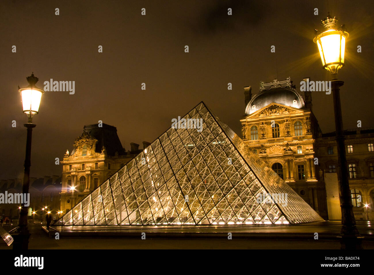 The Lourve Pyramid Paris France illuminated at night with reflection in ...