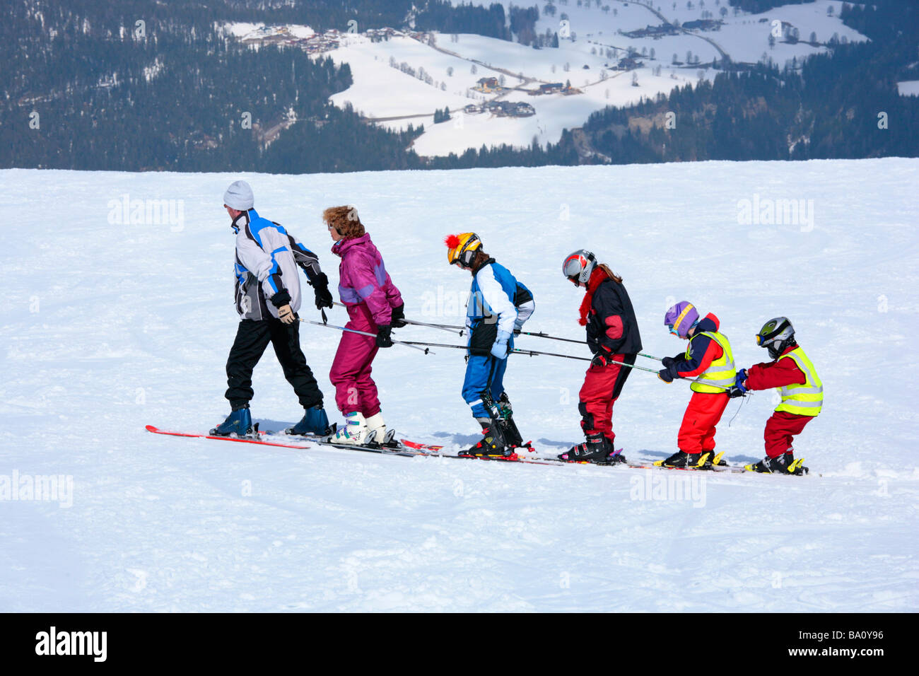 a family Alpine skiing in single file on Reiteralm in Styria, Austria ...