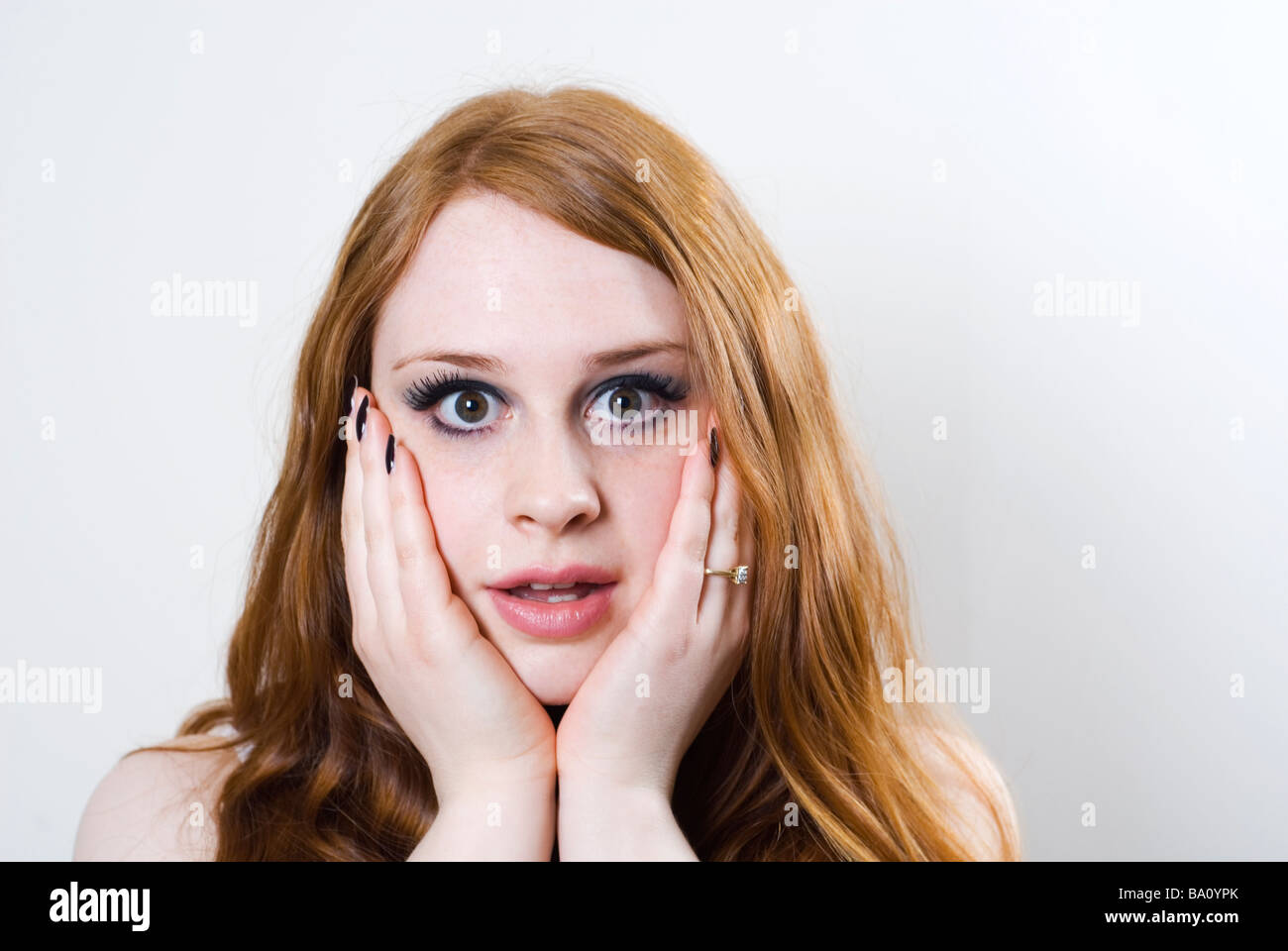 Shocked young woman hands grabbing face Stock Photo - Alamy