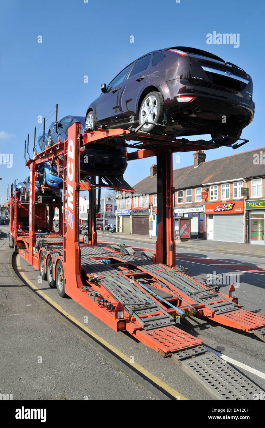 Car transporter delivery lorry truck unloading cars from trailer in ...