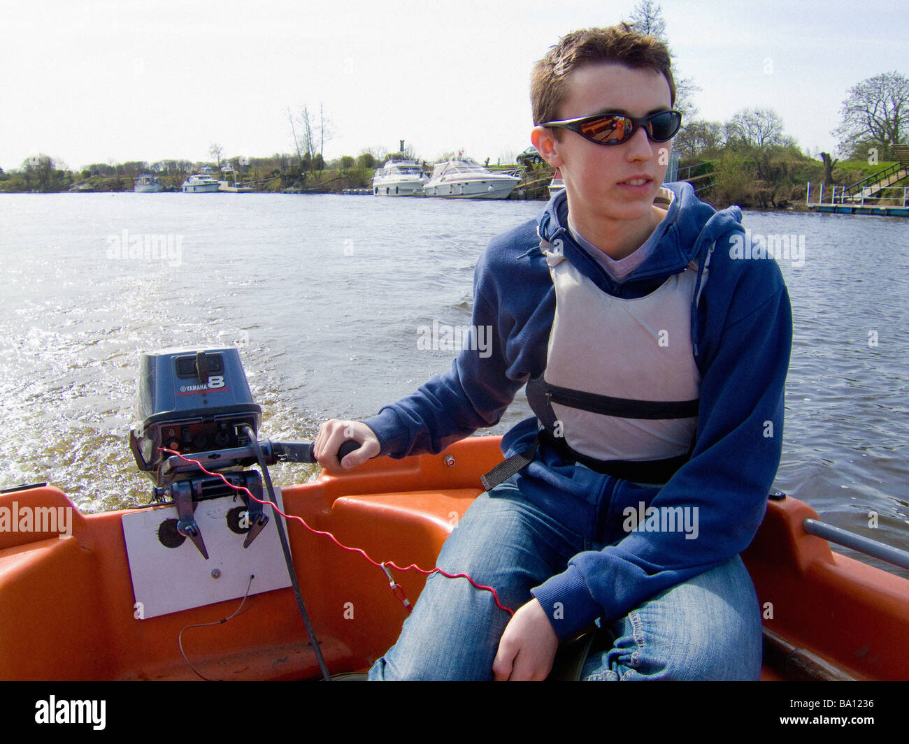 Young caucasian male, wearing a kill cord whilst steering a powerboat ...