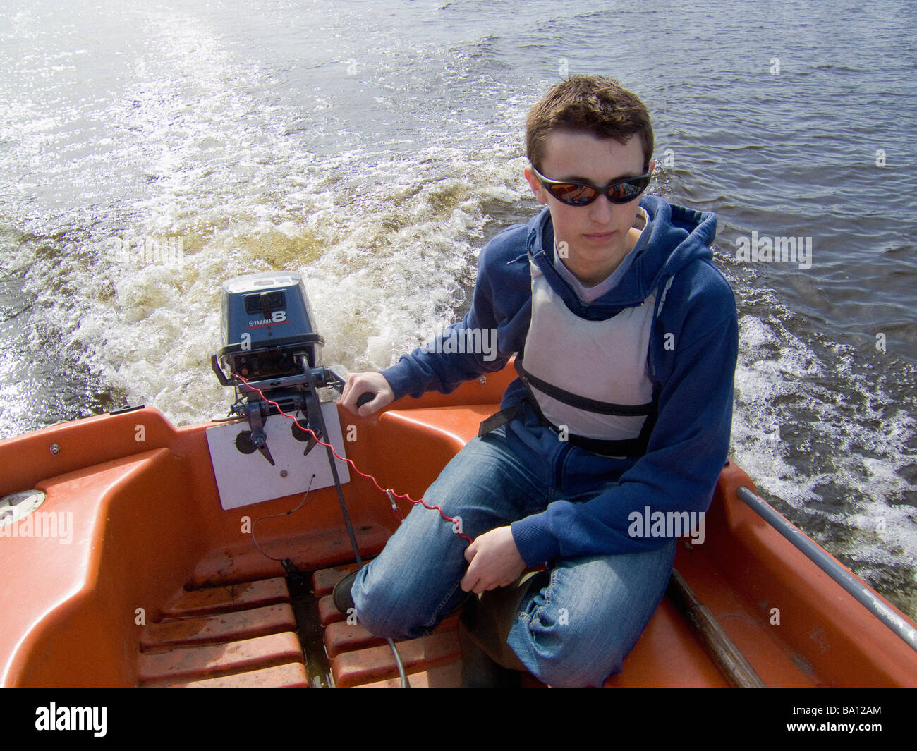 Young caucasian male, wearing a kill cord whilst steering a powerboat ...