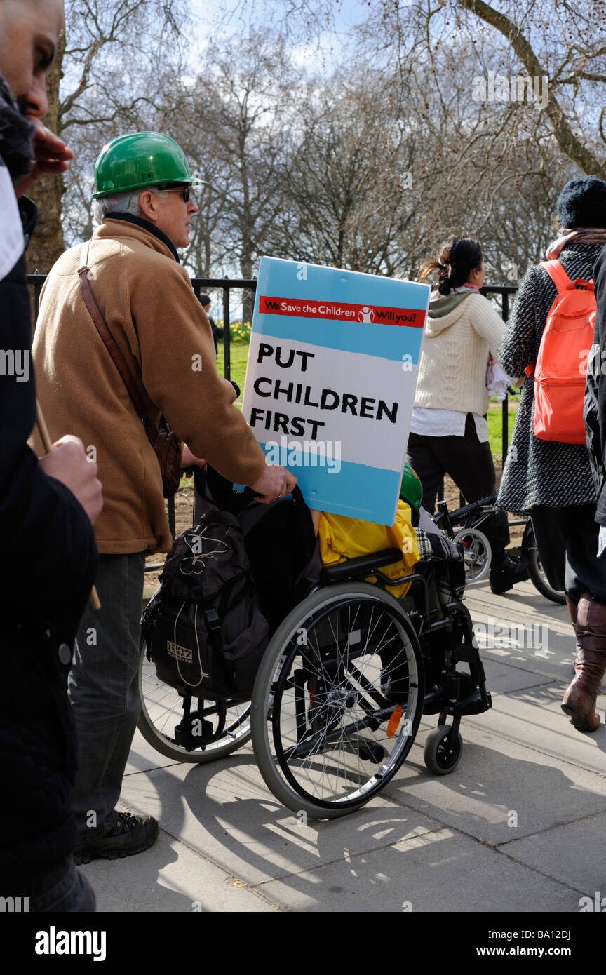 Man pushing wheelchair with save the children placard on G20,Put People ...