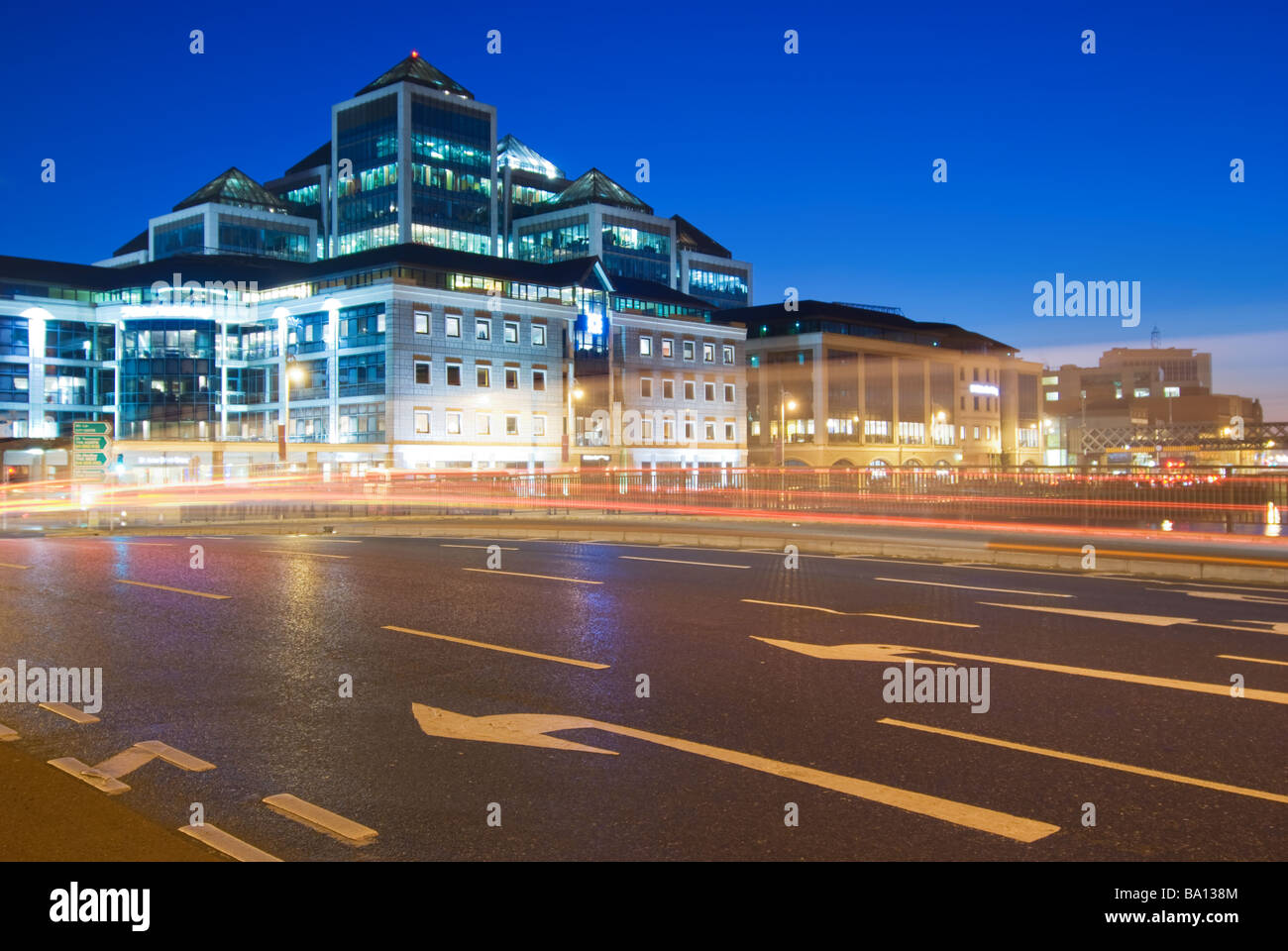 Rush hour traffic streams by the modern face of Dublin at George's Quay ...