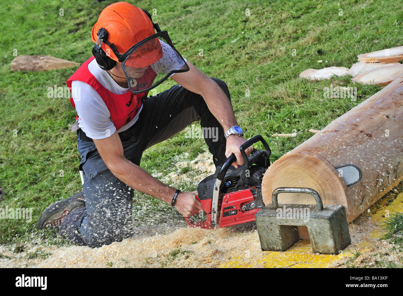 Close up of a logger using a chainsaw to cut accurate slices from a log ...