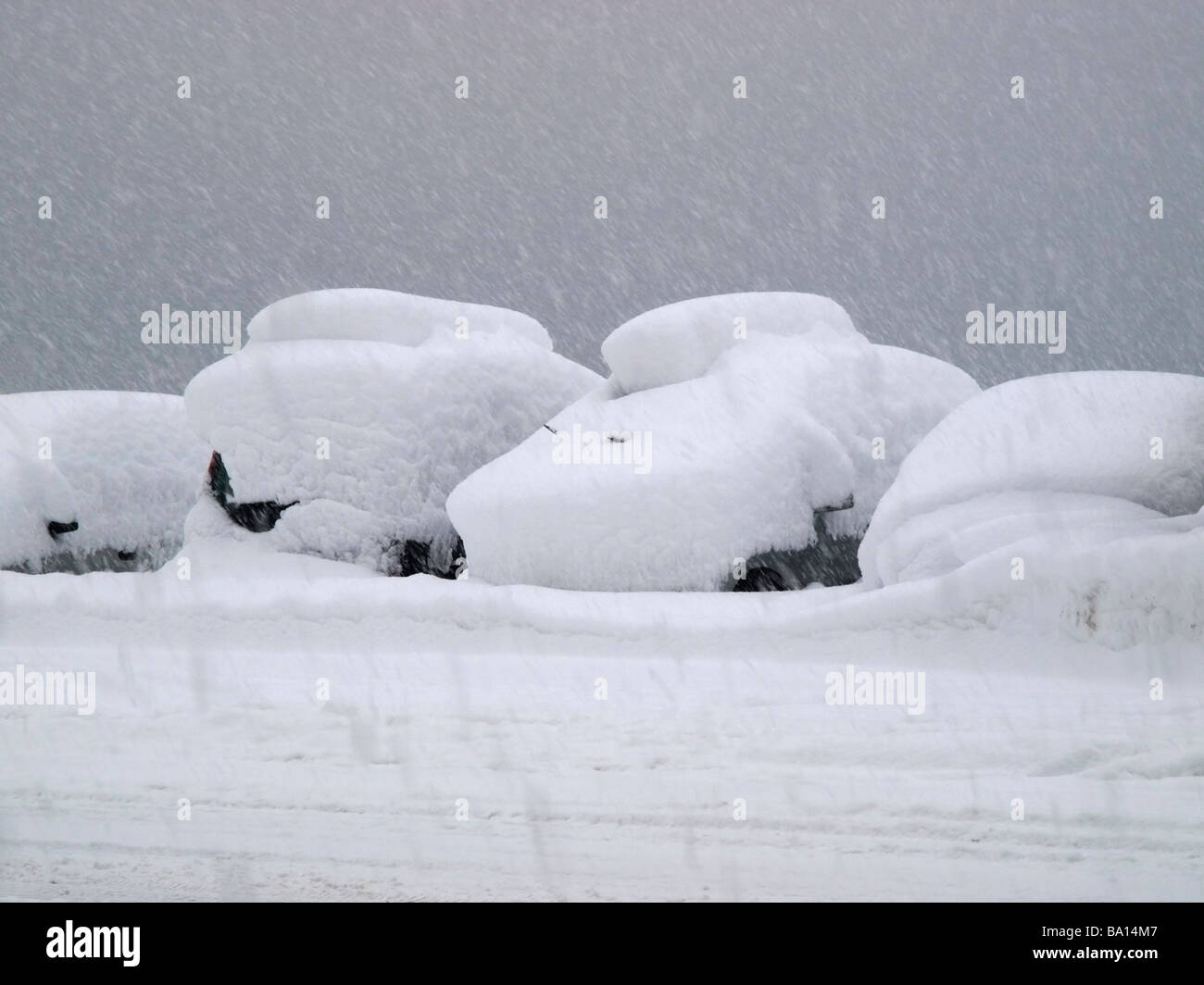 Winter scene with heavy snowfall and cars covered with snow, looking ...